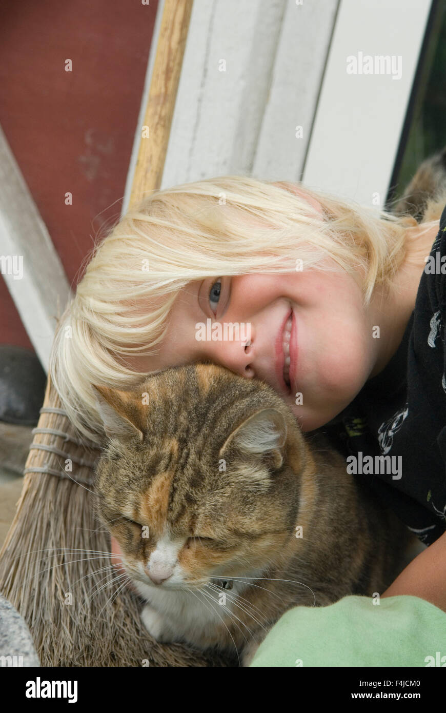 Boy cuddling cat, smiling Stock Photo - Alamy