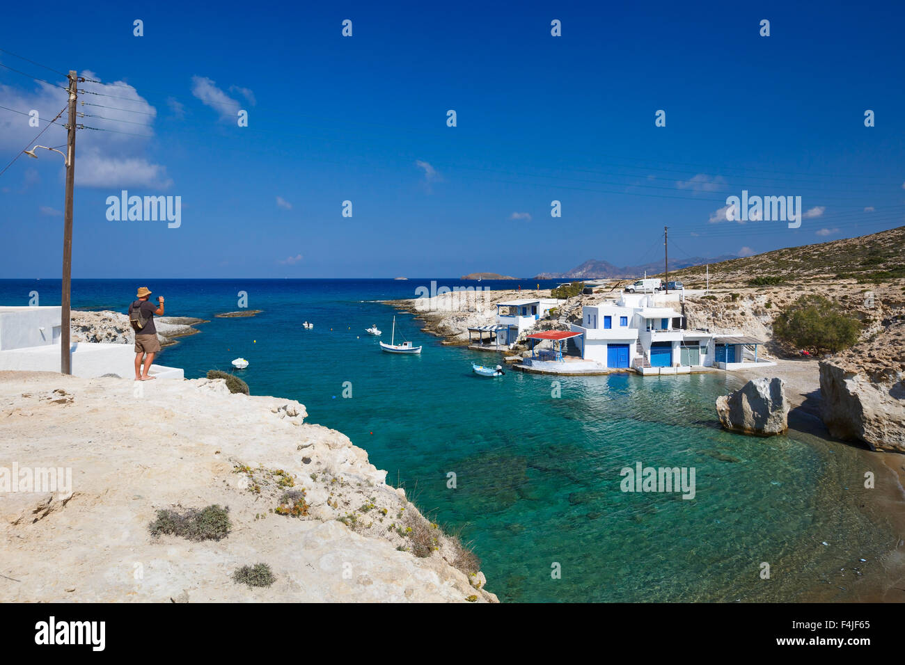 Tourist taking photos of traditional boat houses in Mytakas, Milos ...