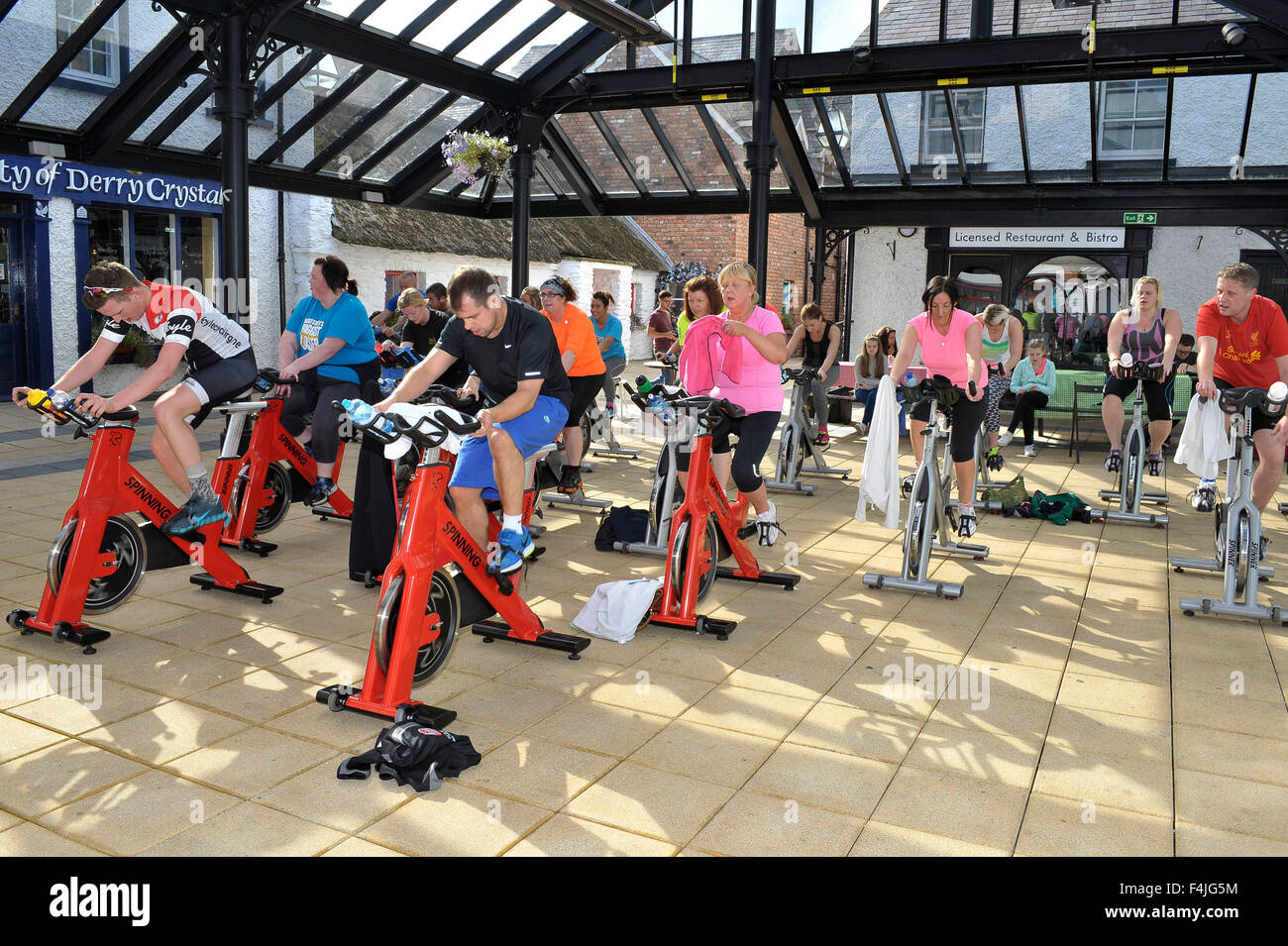 People riding spin bicycles outdoors Stock Photo - Alamy