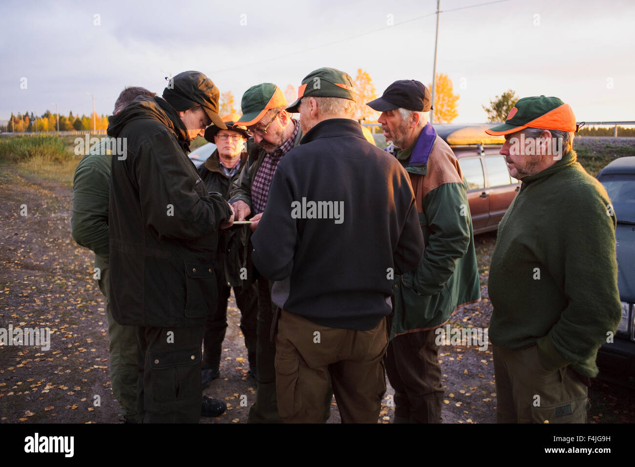 Group of men standing together consulting map Stock Photo - Alamy