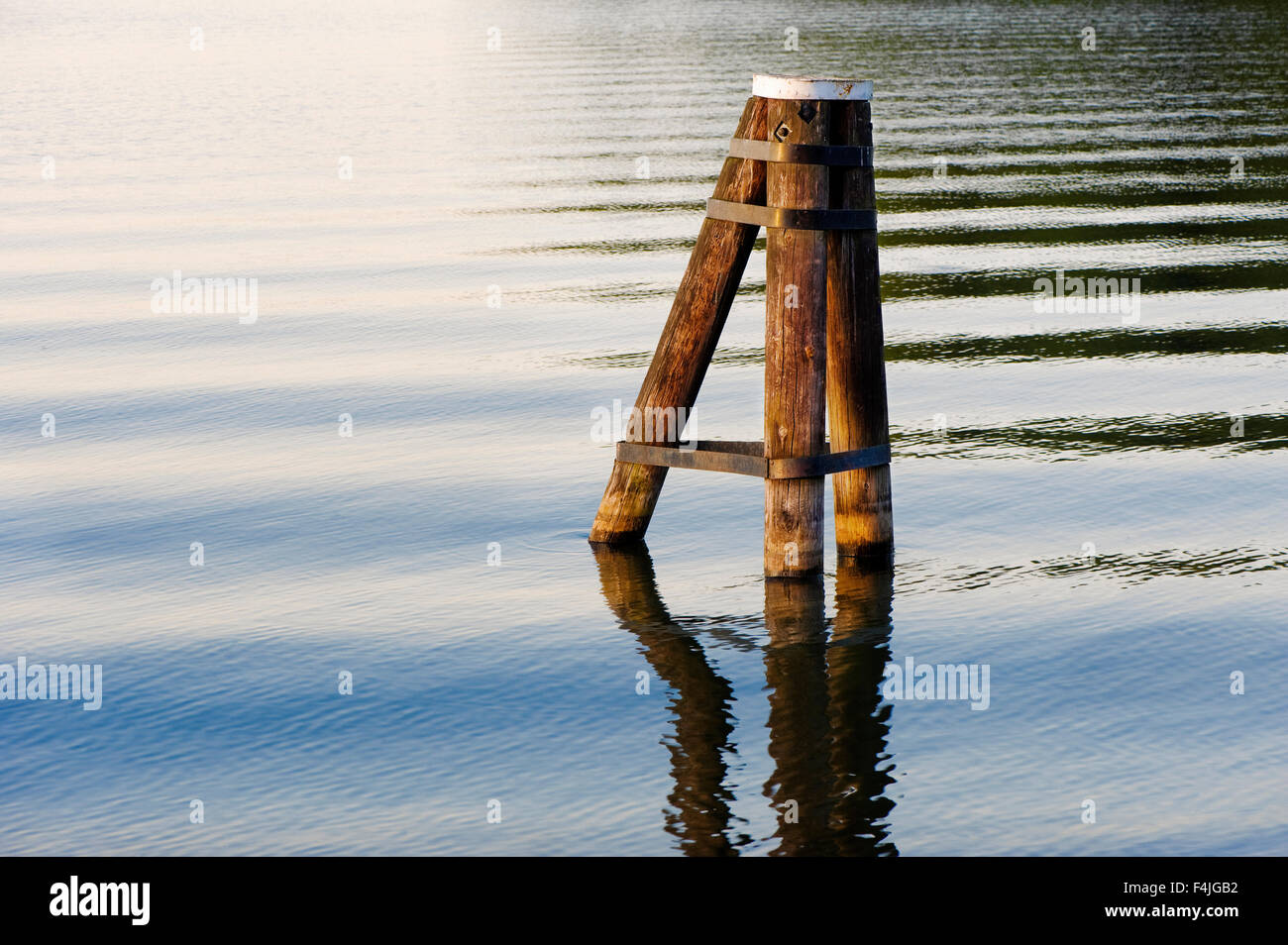 Wooden post in lake Stock Photo - Alamy