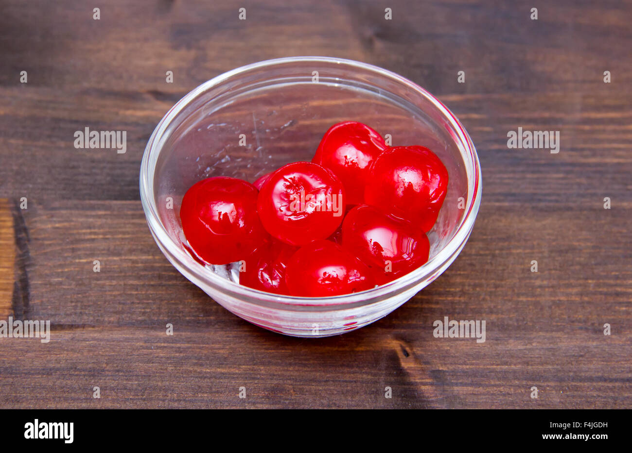 Candied cherries on bowl on wooden table Stock Photo - Alamy