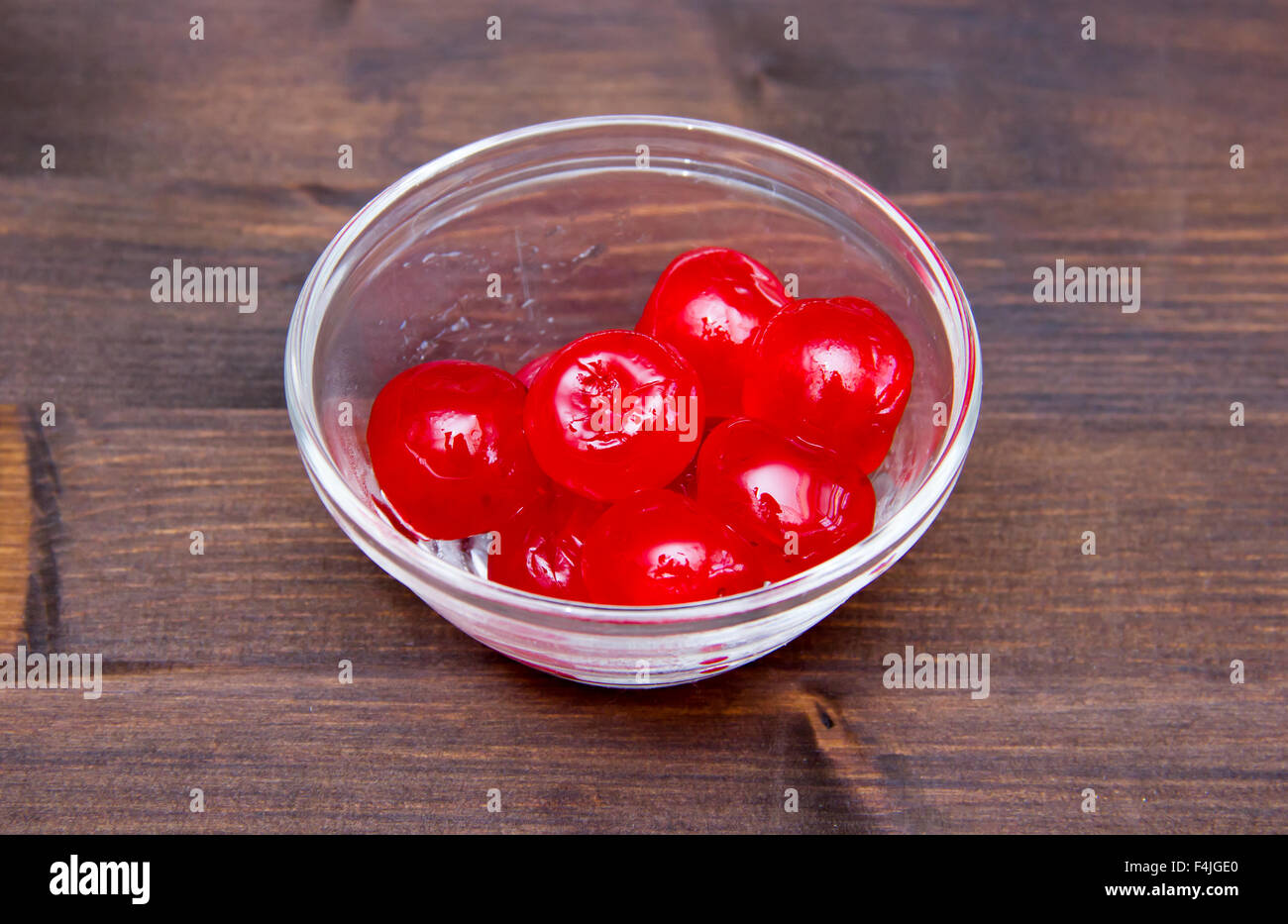 Candied cherries on bowl on wooden table Stock Photo - Alamy