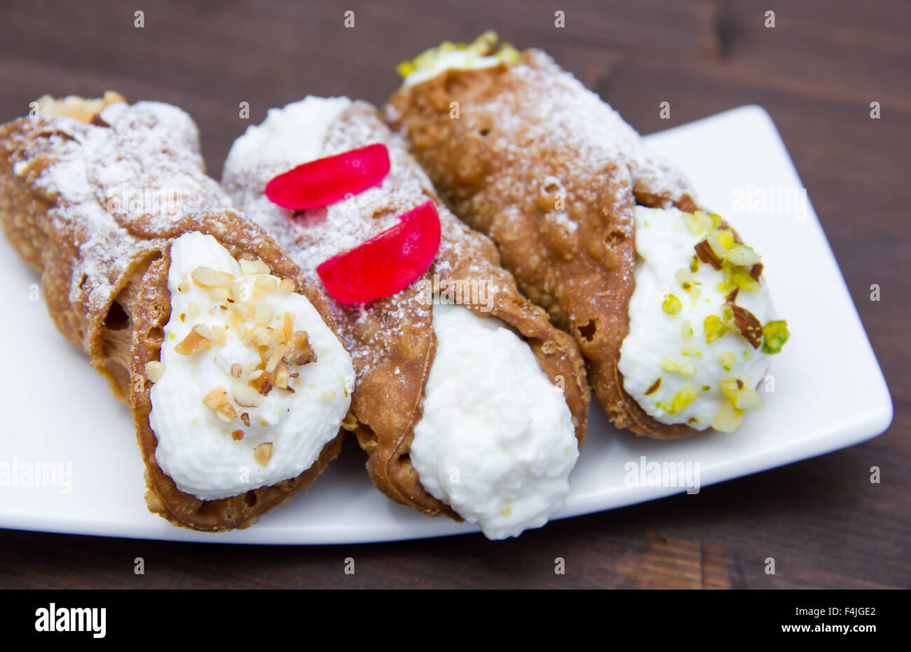 Cannoli with ricotta cheese on wooden table seen up close Stock Photo ...