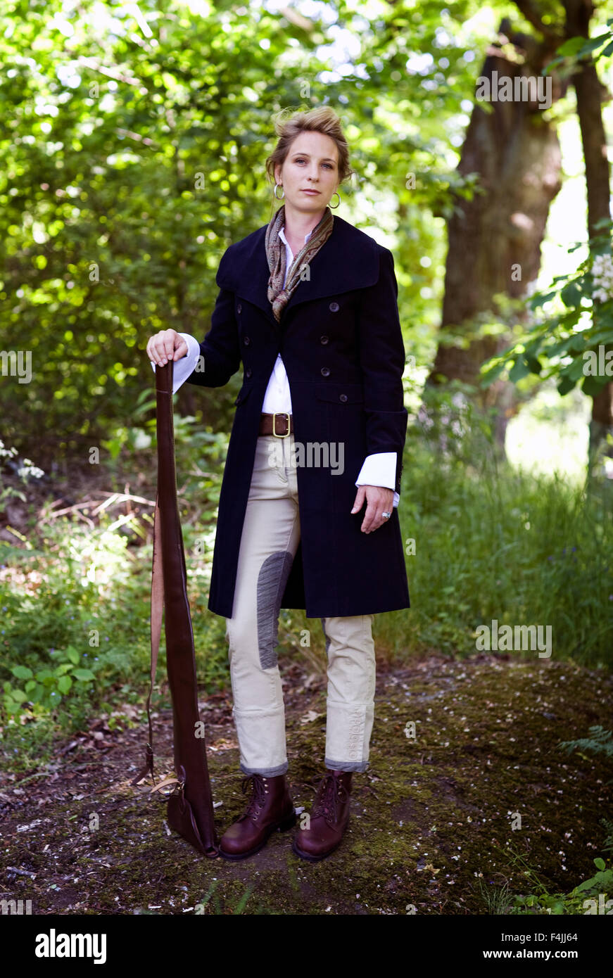 Woman standing and posing with rifle Stock Photo - Alamy