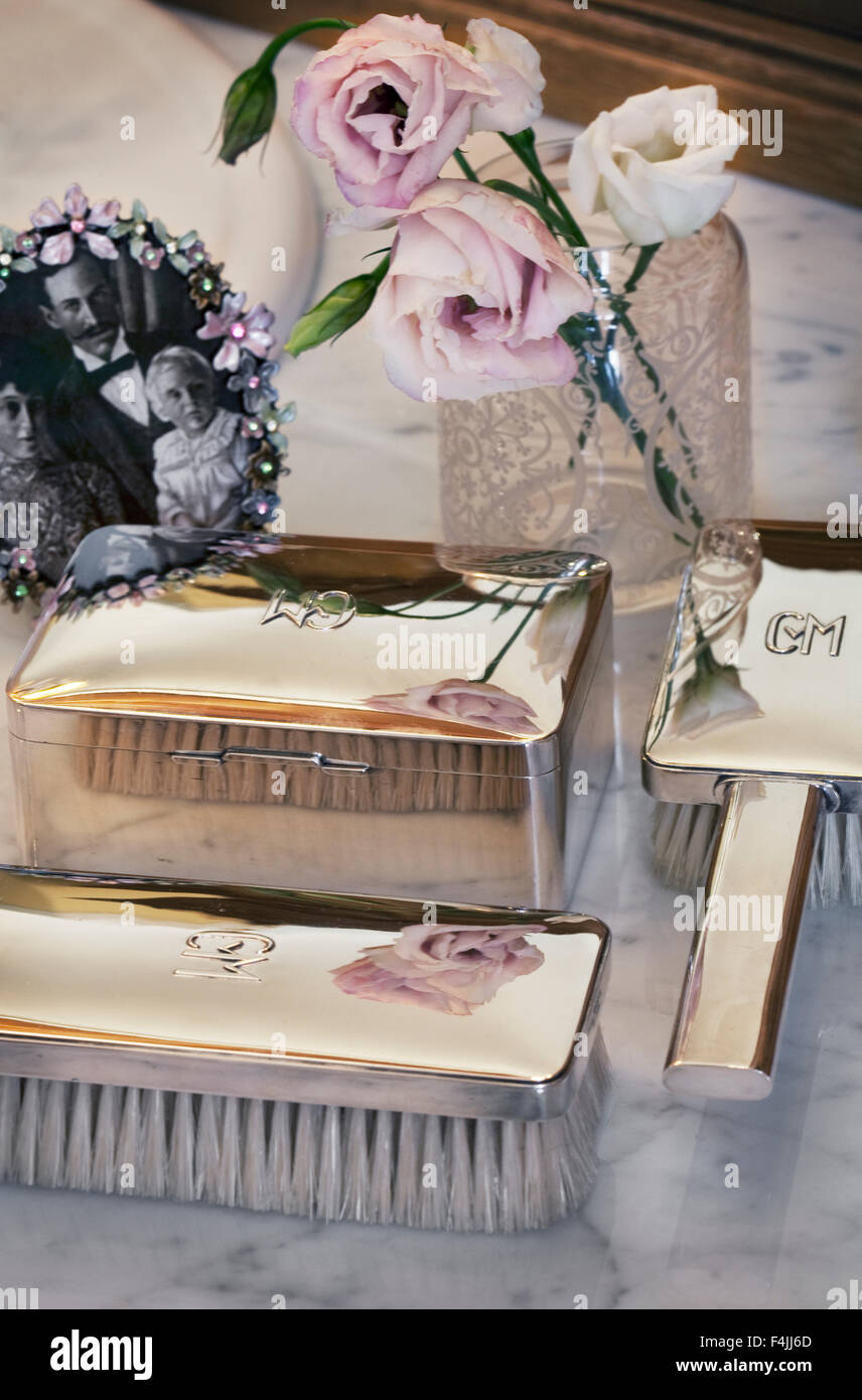 Silver brushes, box and pink flowers in vase Stock Photo - Alamy