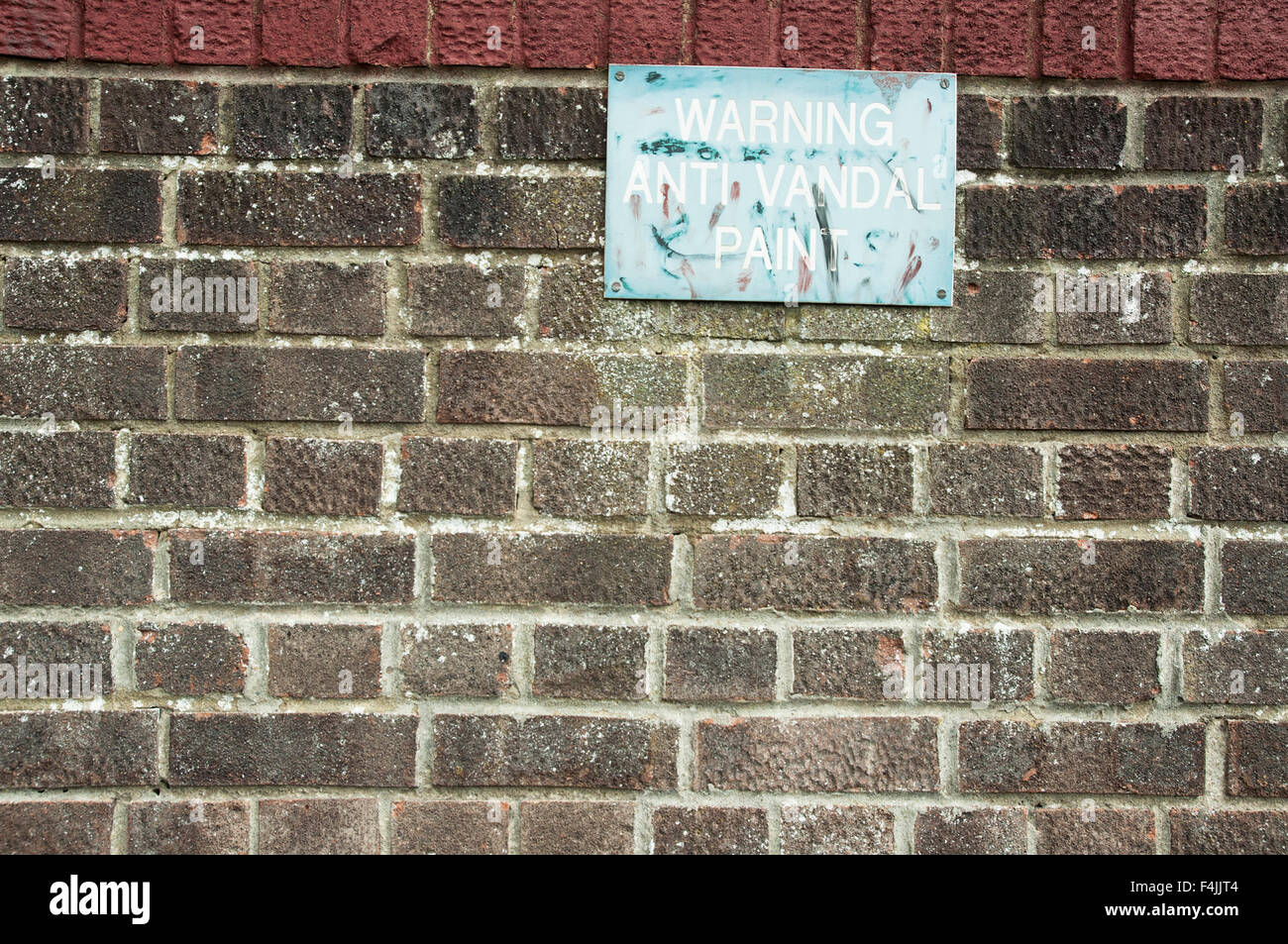 A wall with a sign warning. Warning anti vandal paint Stock Photo - Alamy