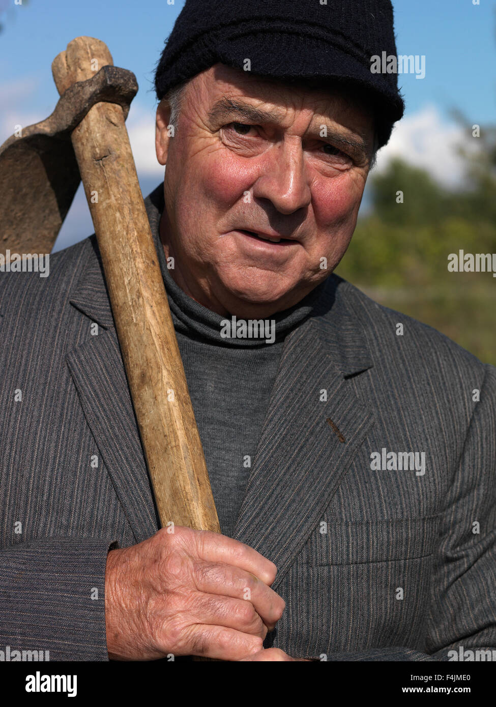 Italy, Tuscany, portrait of senior farmer holding trowel Stock Photo ...
