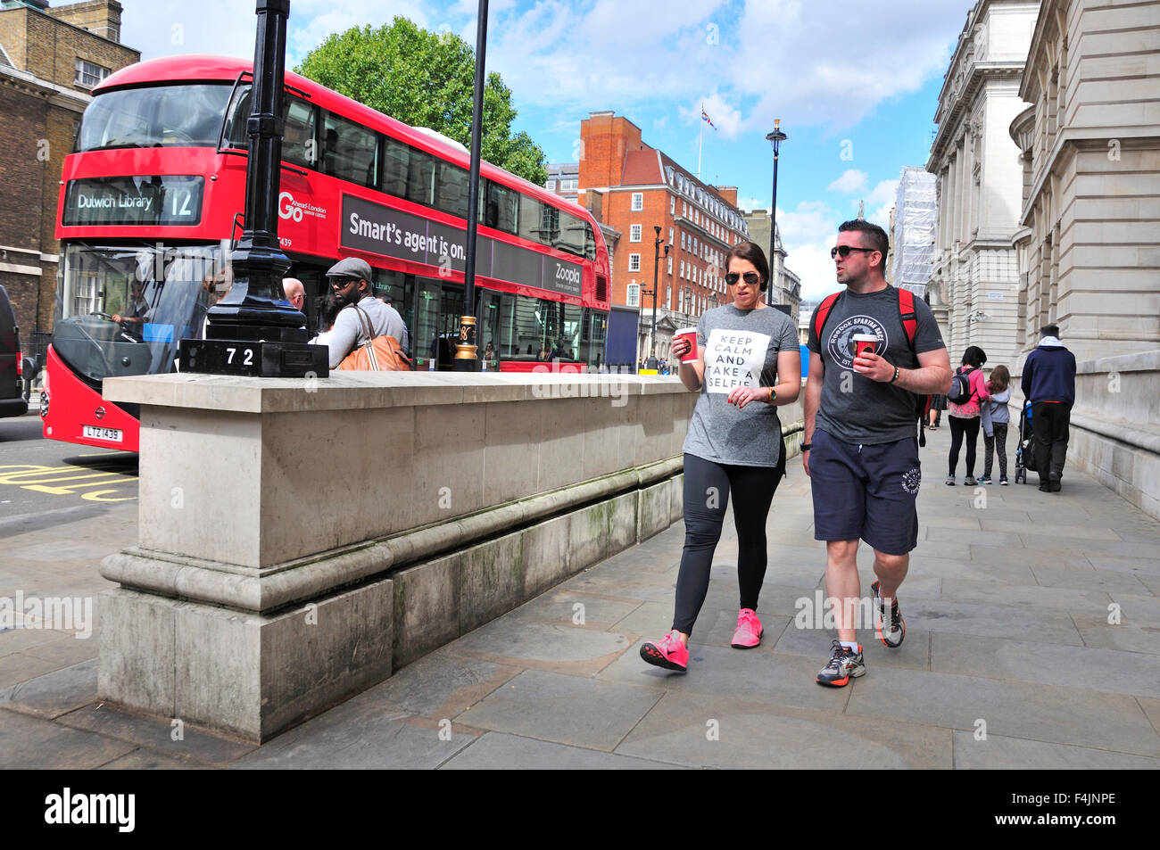 London, England, UK. Two people carrying takeaway coffee in Whitehall ...
