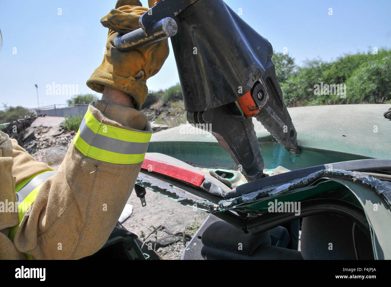 Firefighters use power tools to rescue trapped passengers from a car ...