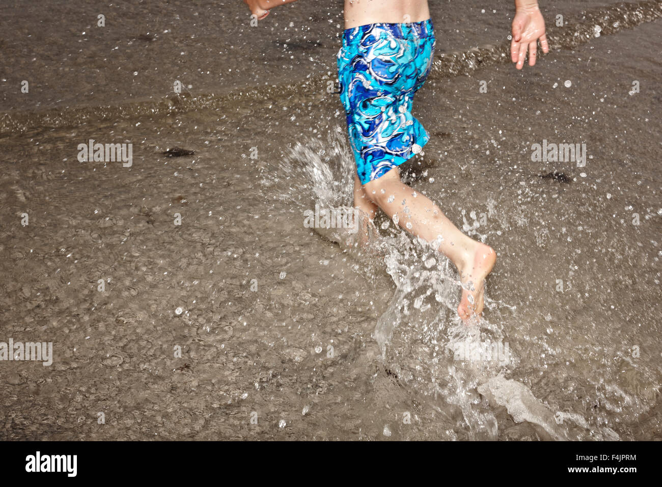 Boy running through water Stock Photo - Alamy
