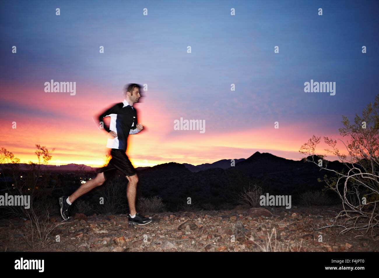 Man running on mountain at sunrise Stock Photo - Alamy