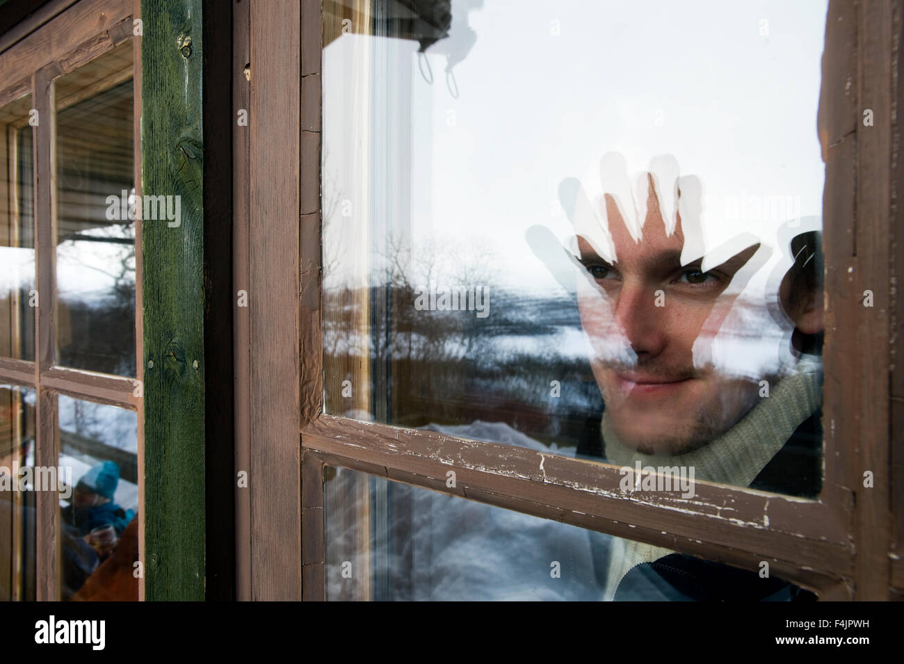 Young man looking out of window Stock Photo - Alamy