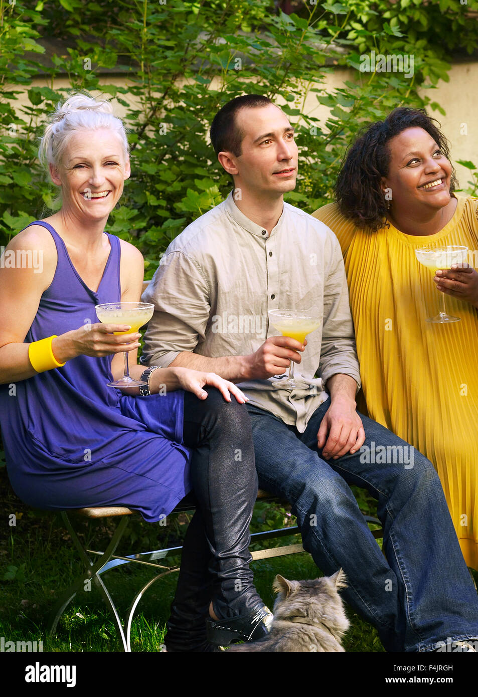 Friends drinking orange juice in backyard Stock Photo - Alamy