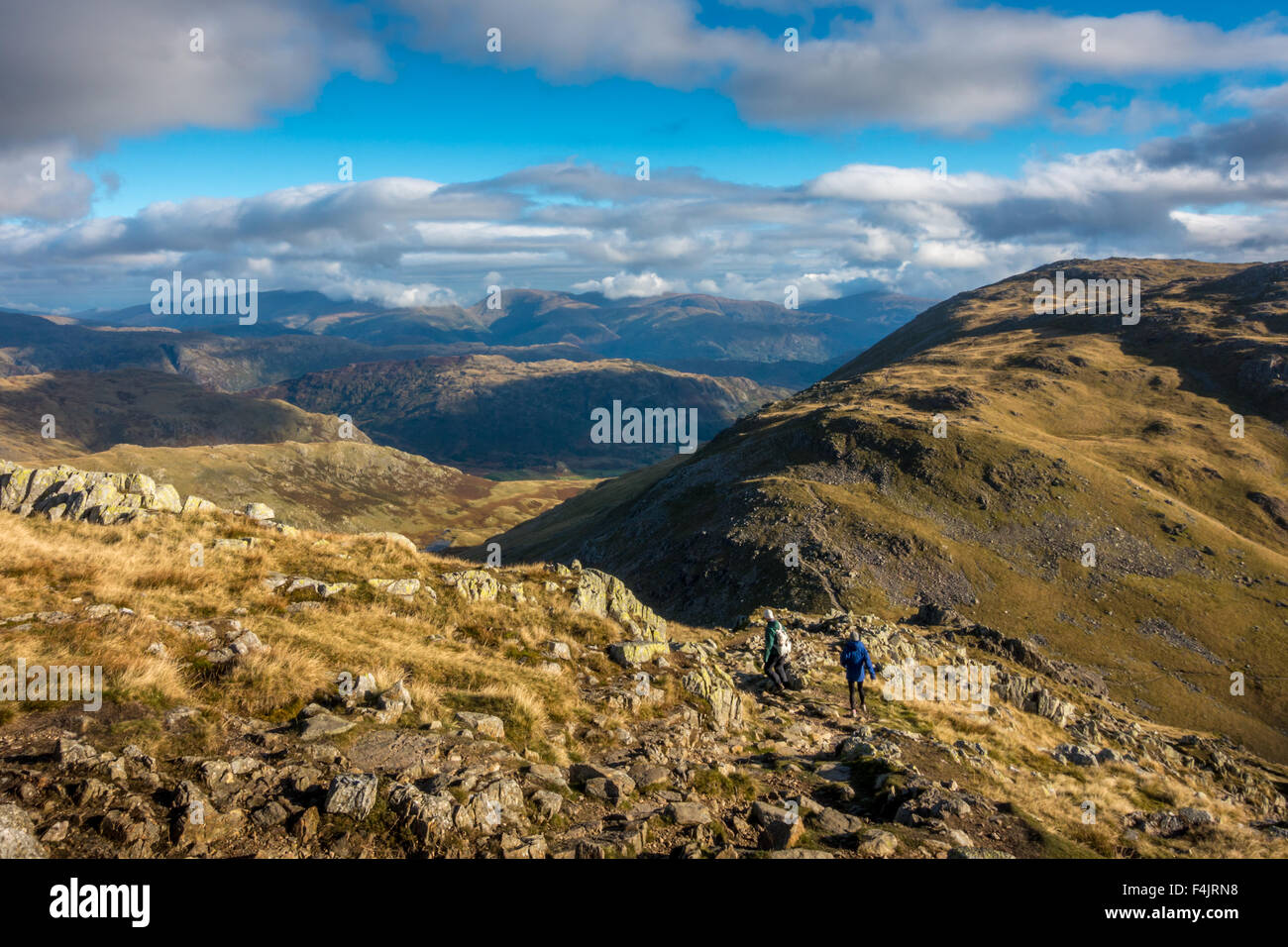 Two people descending Swirl How, looking towards Wetherlam Stock Photo ...