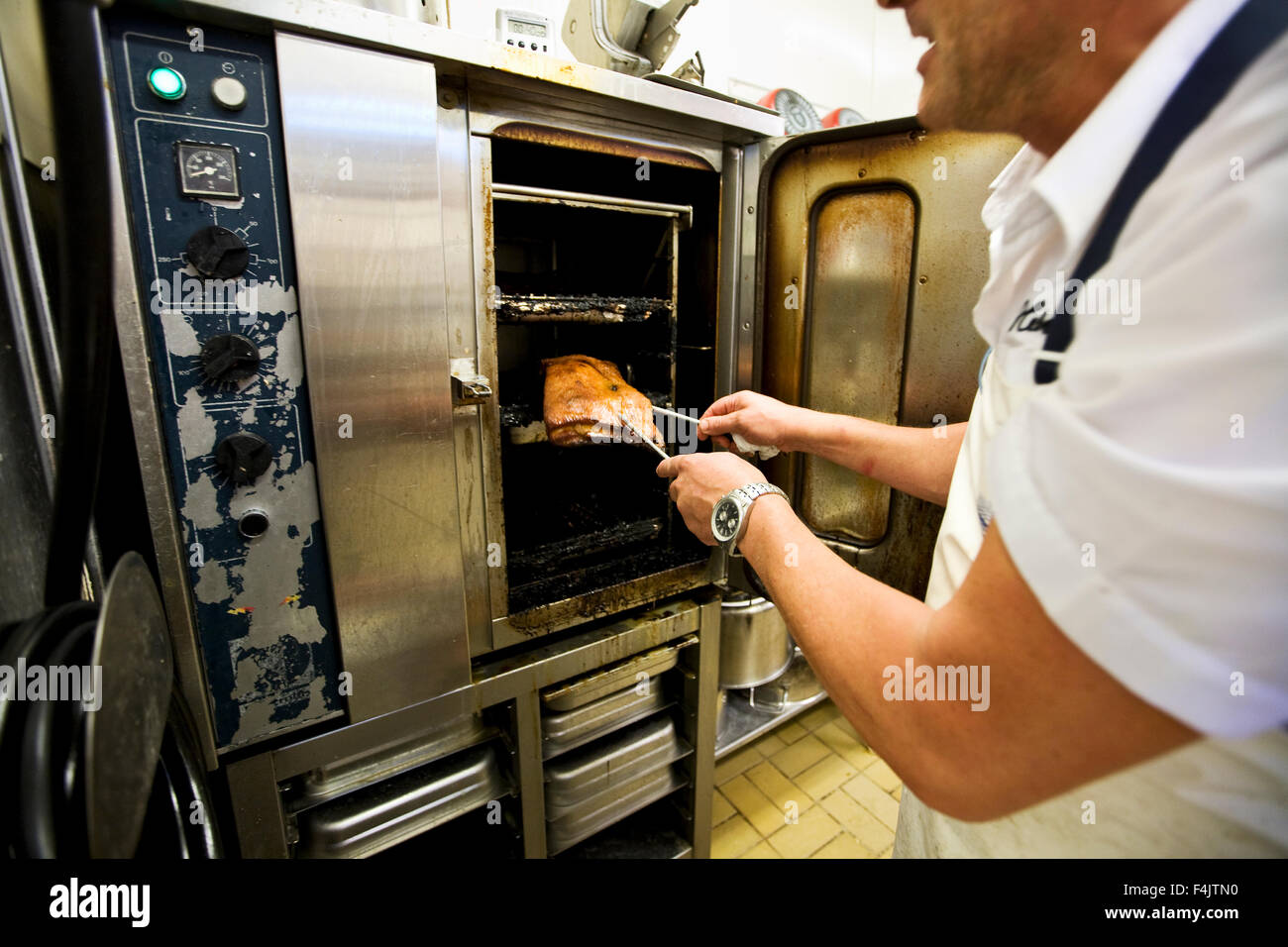 Man taking meat from oven Stock Photo - Alamy