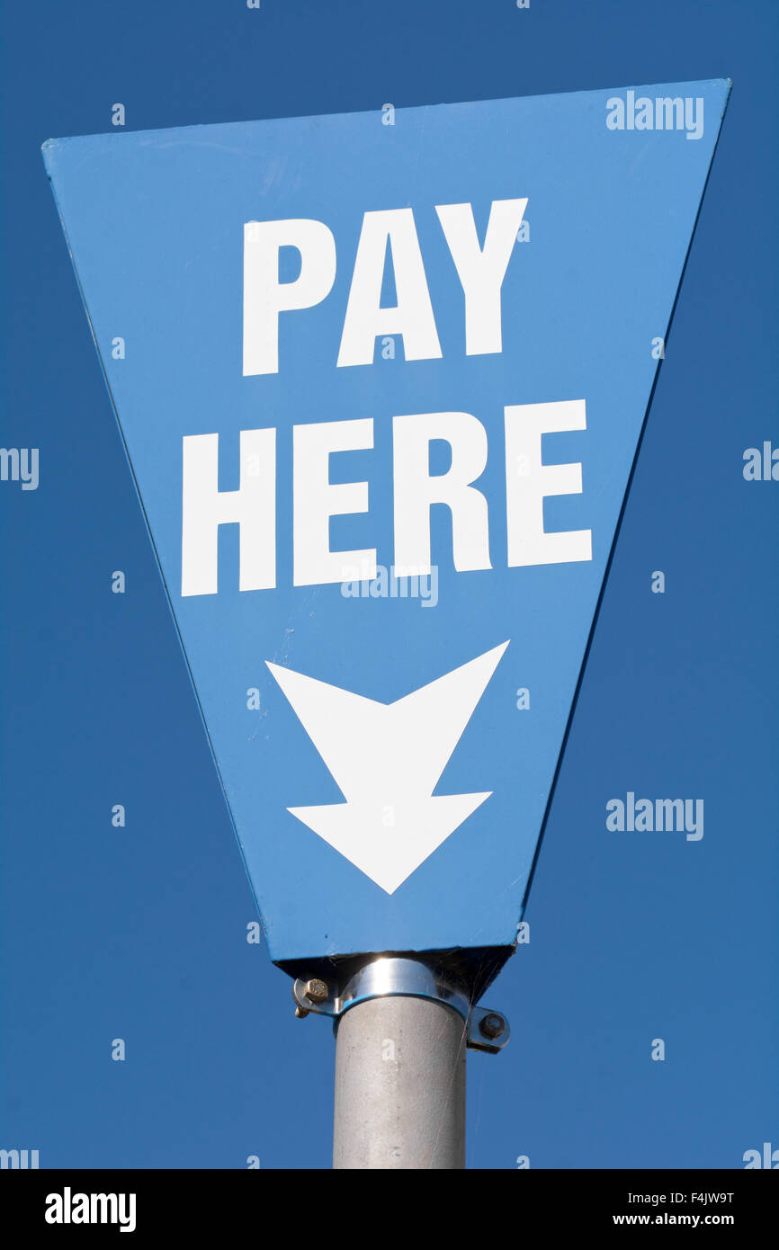 Pay Here sign with big arrow in car park Stock Photo - Alamy
