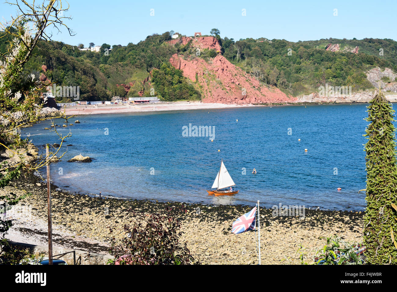 Small sailing boat pulling onto shore on Babbacombe Beach, Torquay ...