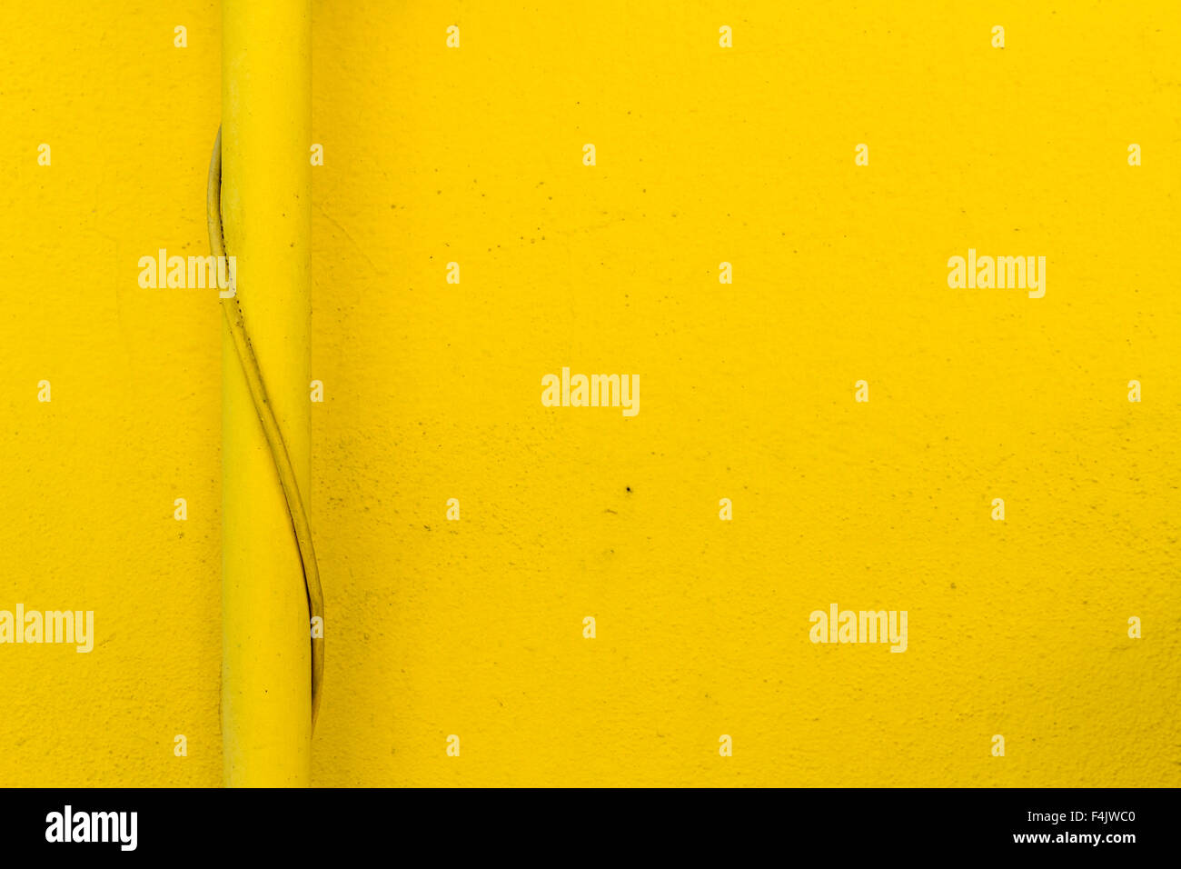 Yellow pipe in front of yellow residential building wall Stock Photo ...