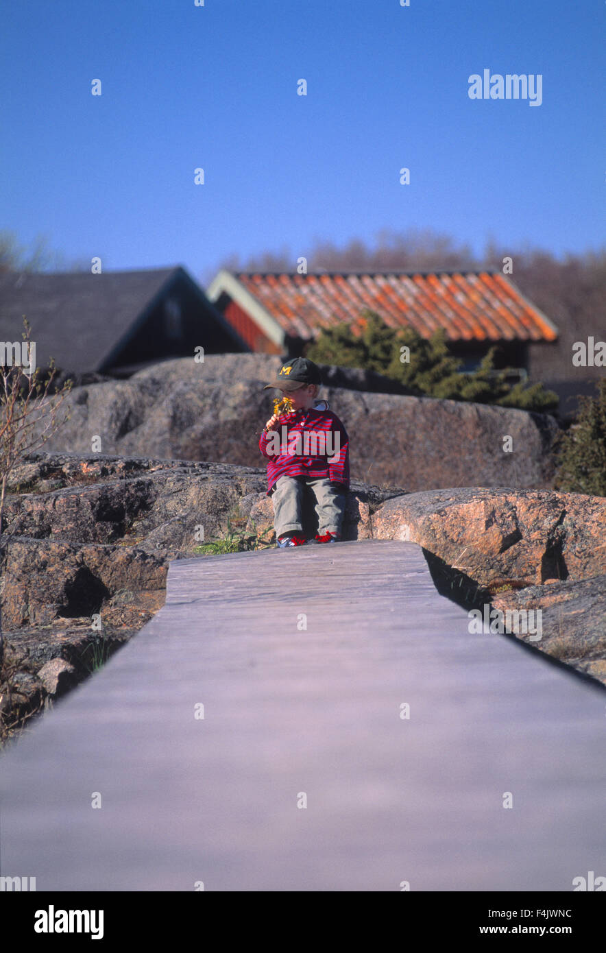 Boy sitting on jetty Stock Photo - Alamy