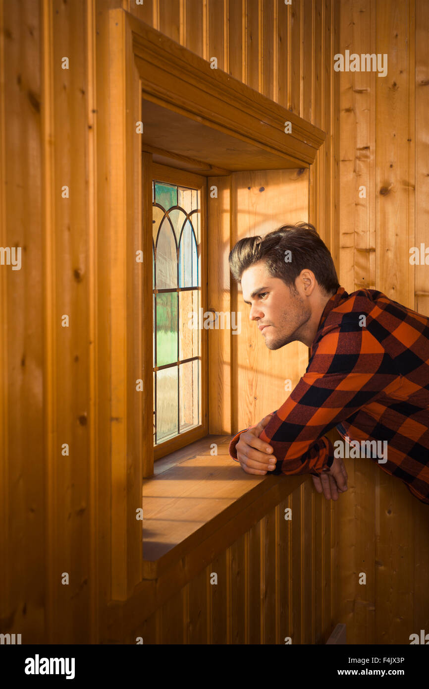 Young man looking through window Stock Photo - Alamy