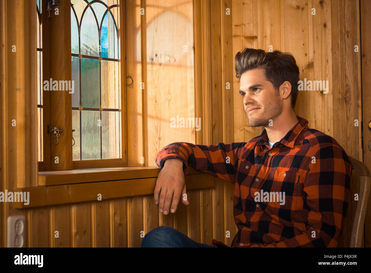 Young man looking through window, smiling Stock Photo - Alamy