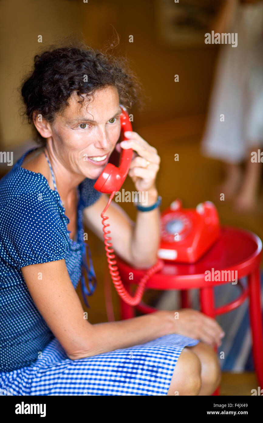 Woman talking on landline phone, smiling Stock Photo - Alamy