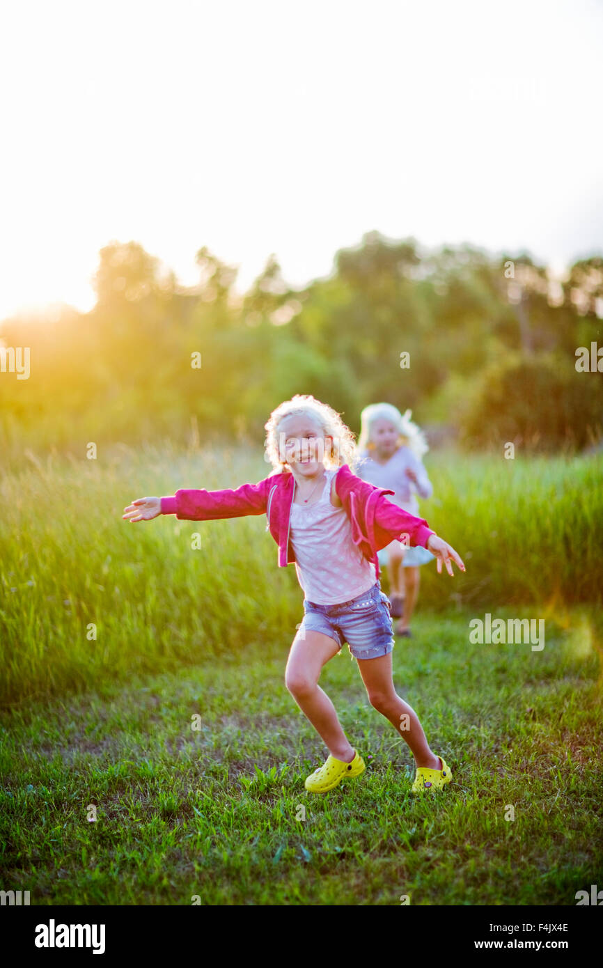 Two girls running through field Stock Photo - Alamy