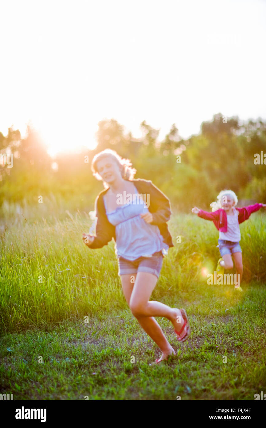 Two girls running through field Stock Photo - Alamy