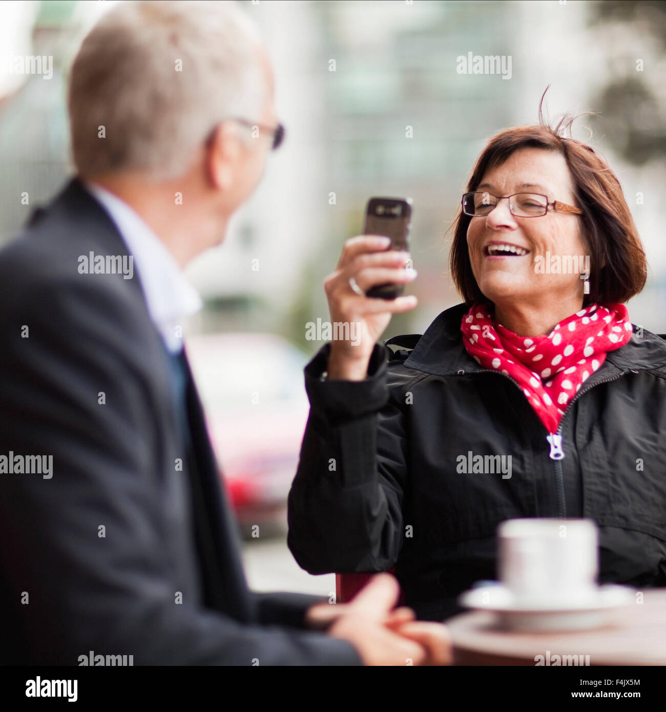 Women photographing man with mobile phone, smiling Stock Photo - Alamy