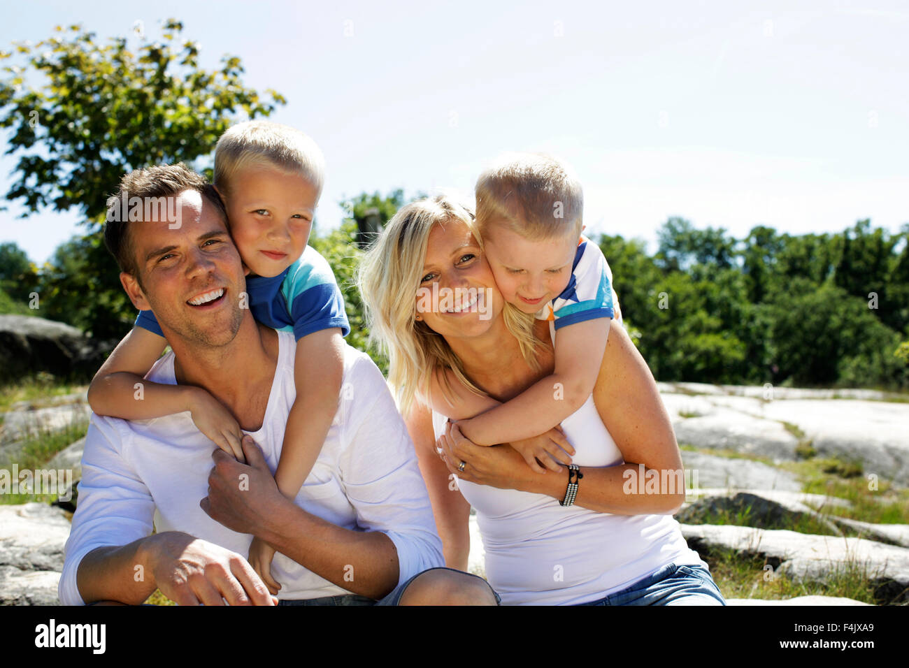 Boys embracing parents, smiling Stock Photo - Alamy