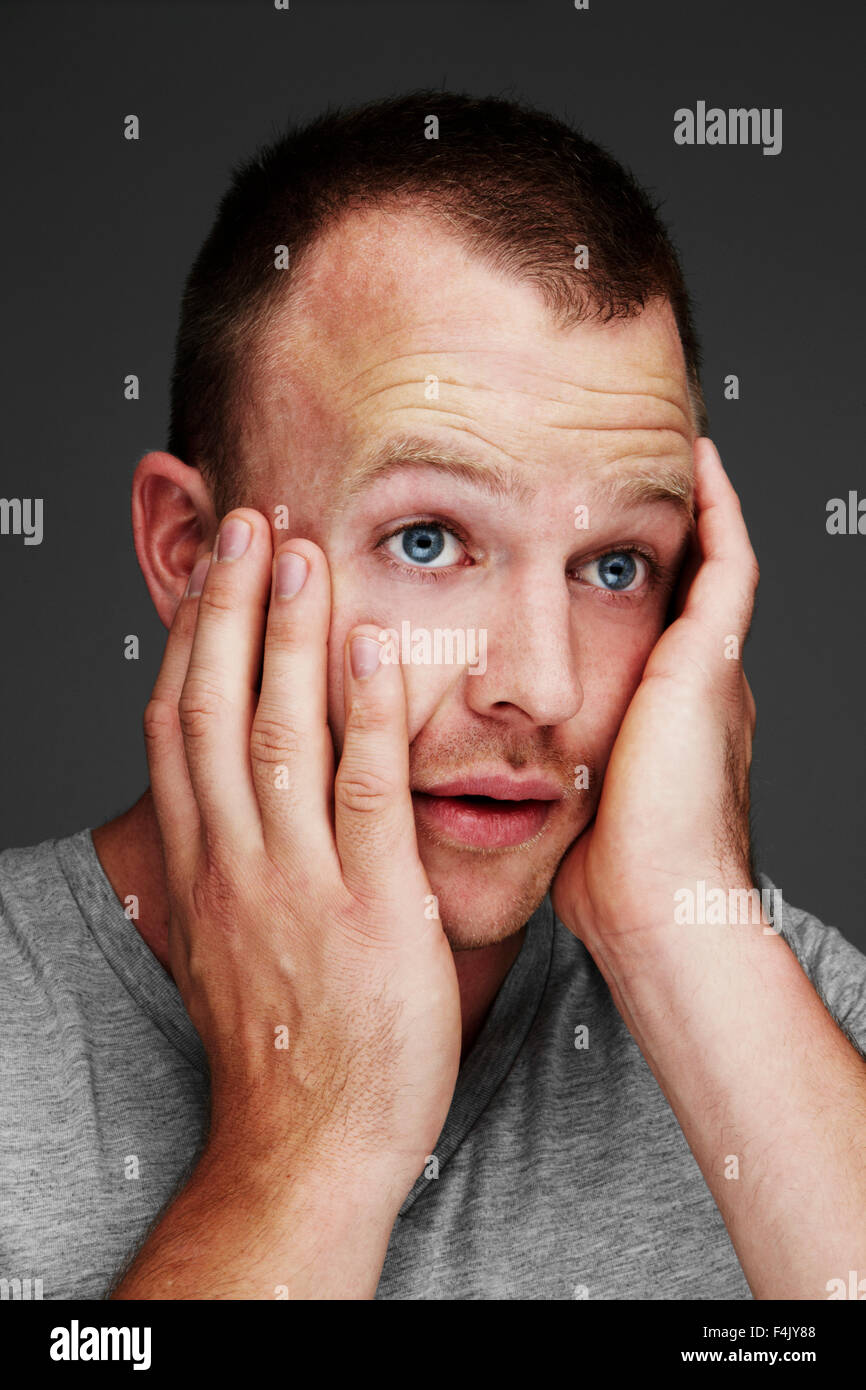 Studio portrait of man with head in hands Stock Photo - Alamy