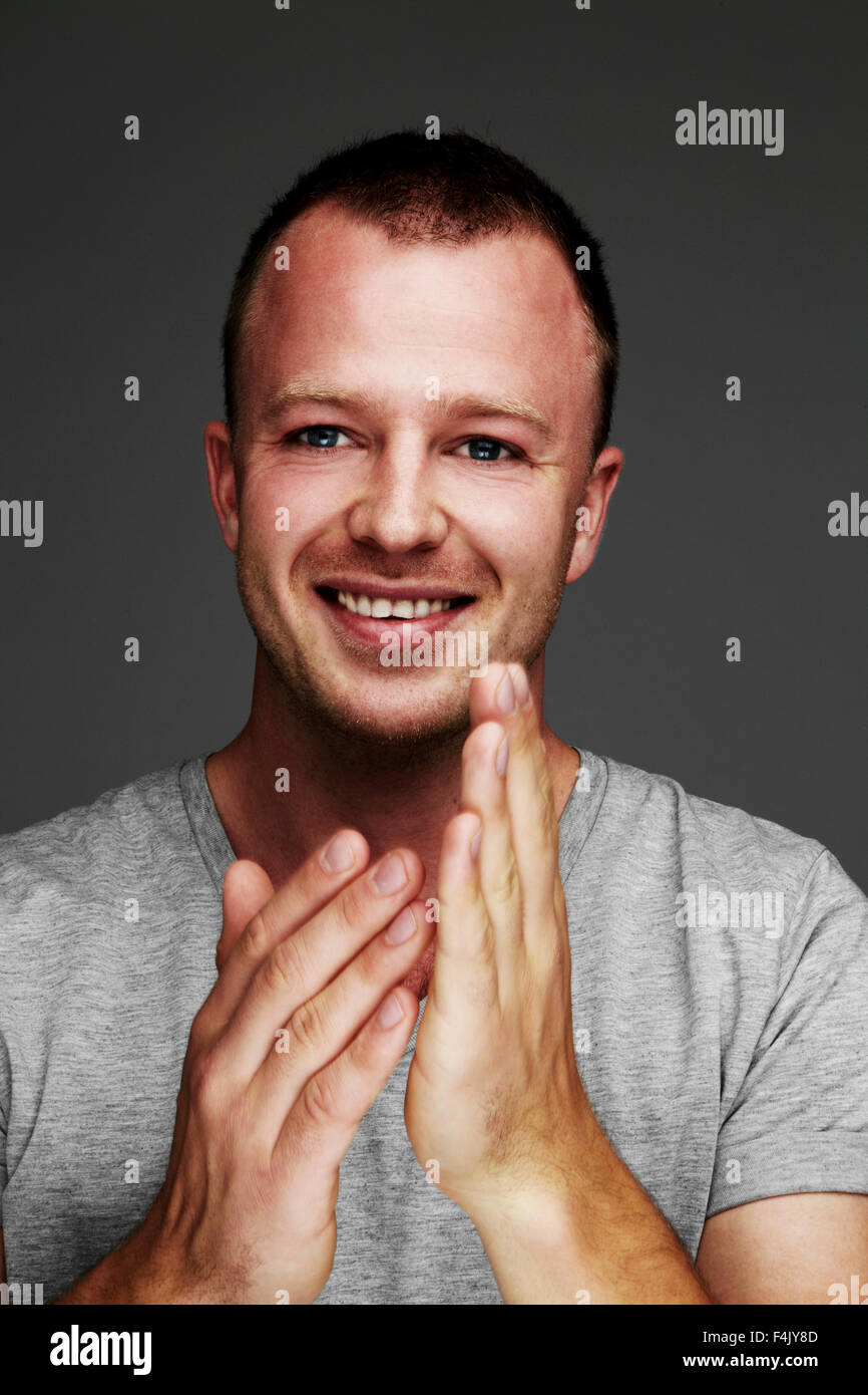 Studio portrait of man clapping hands Stock Photo - Alamy