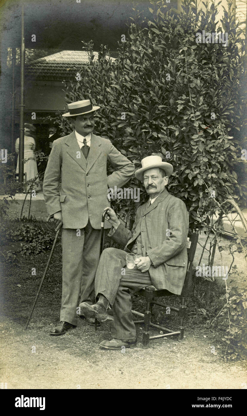 Portrait of two men, one seated, the other standing, Italy Stock Photo ...