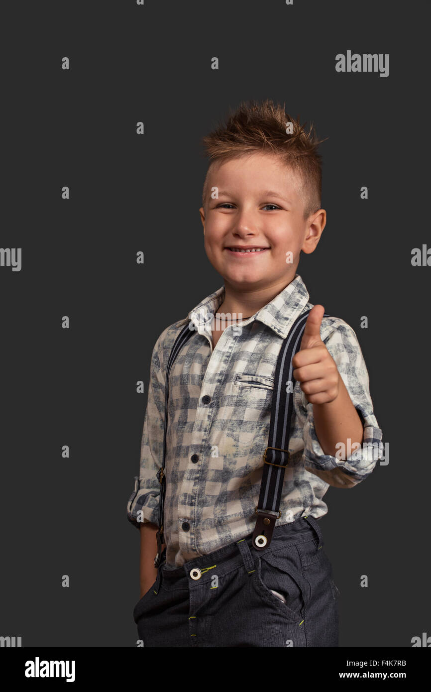 Fashion boy pointing down on grey background Stock Photo - Alamy