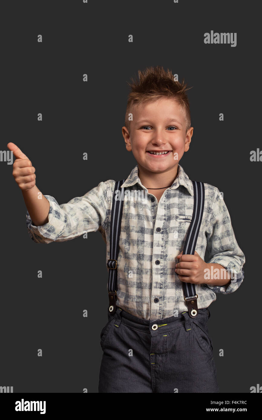 Fashion boy pointing down on grey background Stock Photo - Alamy