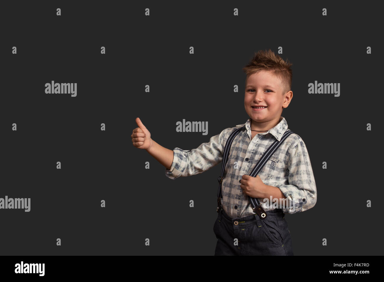 Fashion boy pointing down on grey background Stock Photo - Alamy
