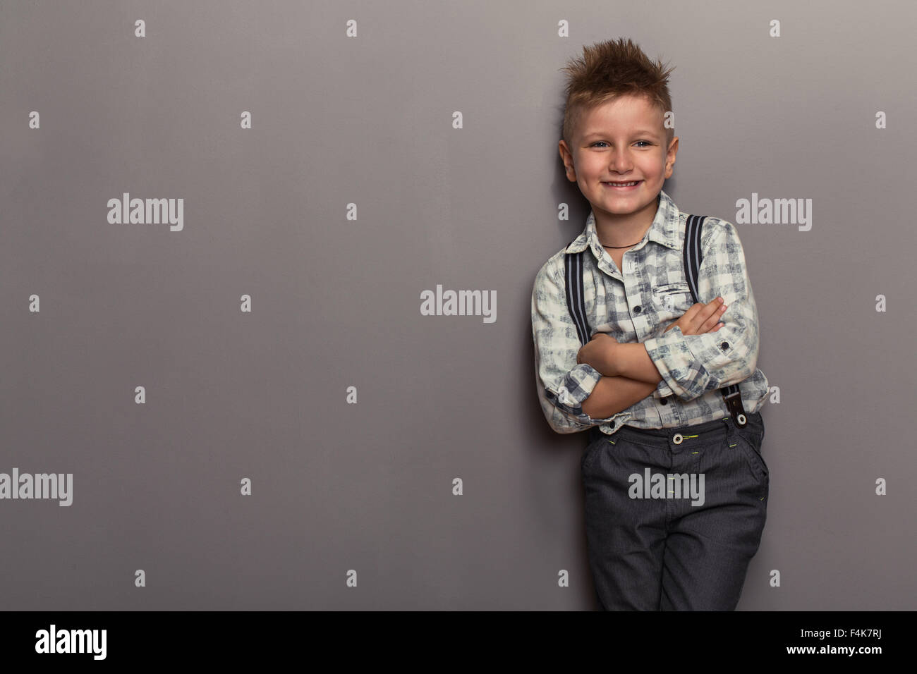 Fashion boy pointing down on grey background Stock Photo - Alamy