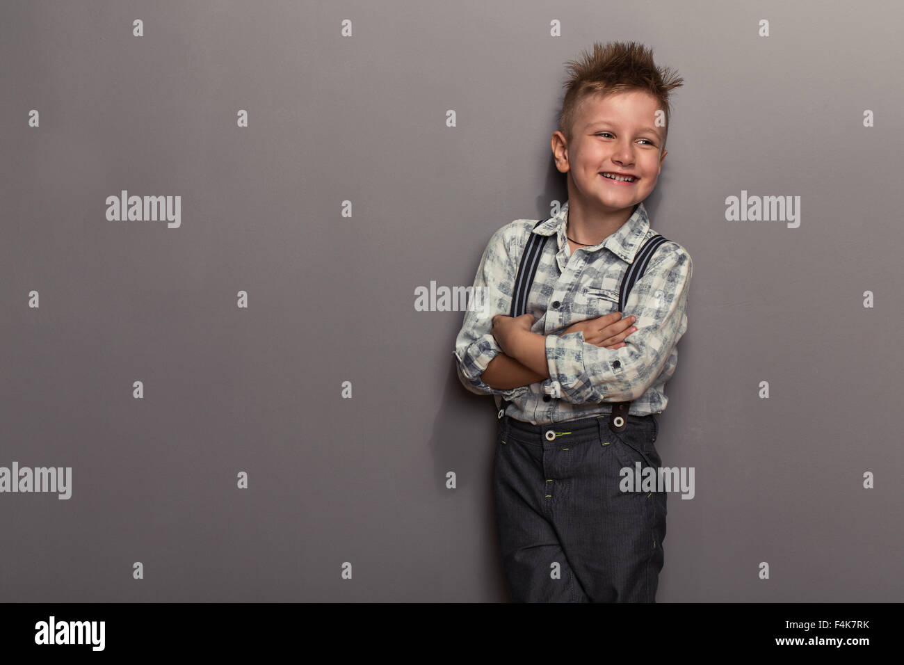 Fashion boy pointing down on grey background Stock Photo - Alamy