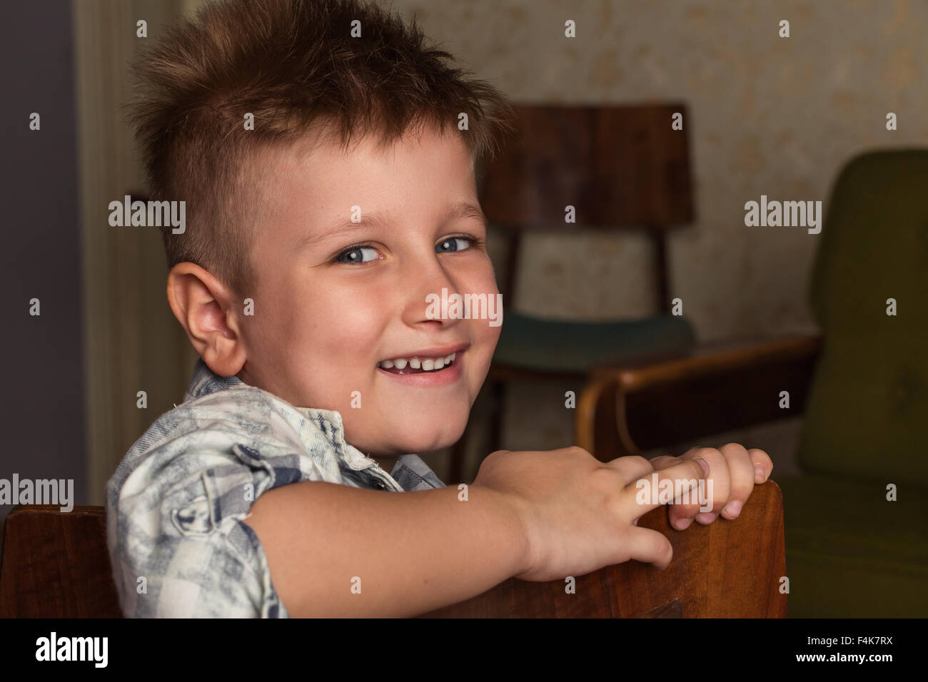 Young boy sitting on a chair on a white background Stock Photo - Alamy