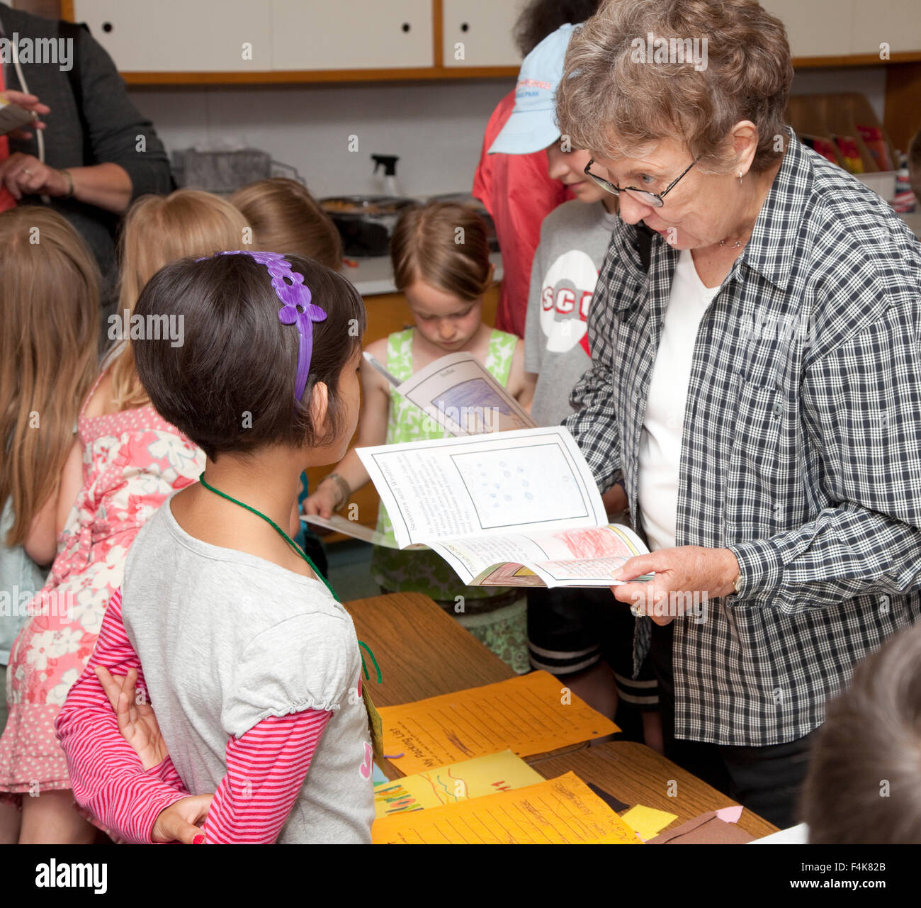 Grandma visiting granddaughters classroom ages 75 and 9 looking at ...