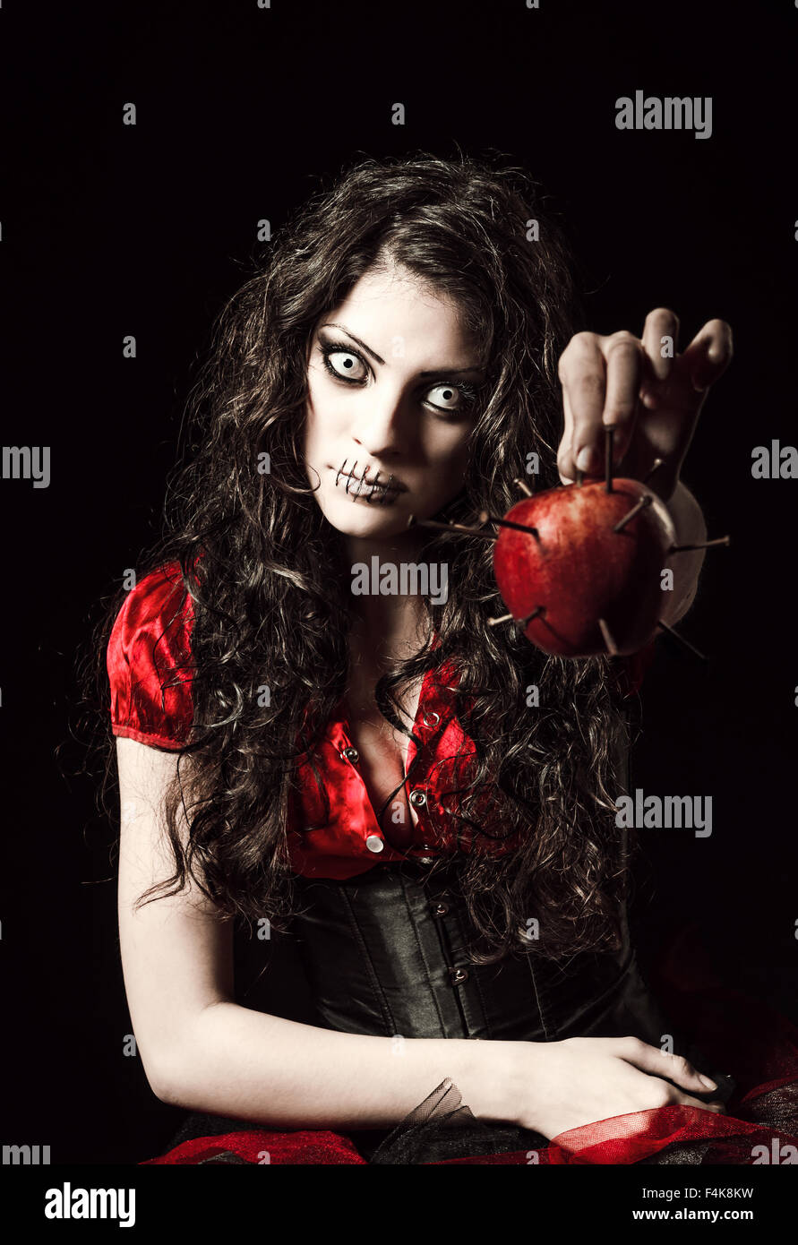 Horror shot: the strange scary girl with mouth sewn shut holds apple ...