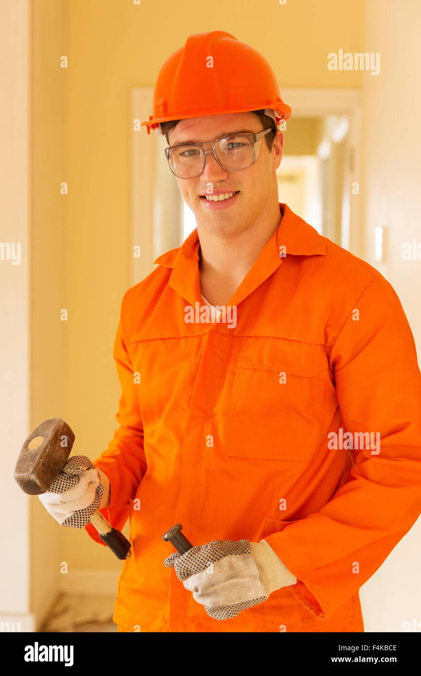 portrait of young builder holding chisel and hammer Stock Photo - Alamy