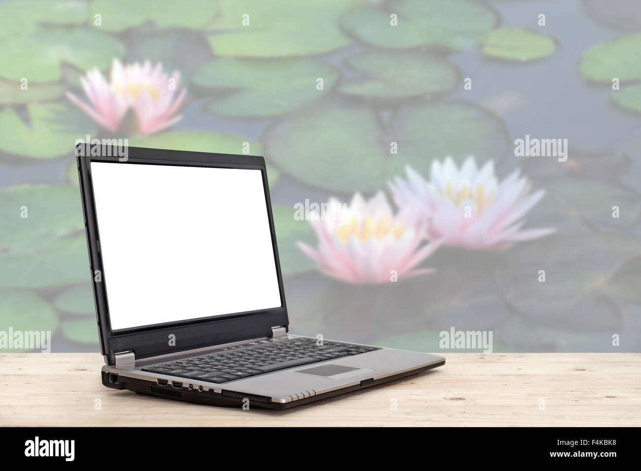 laptop with blank screen on wooden table with lotus flower background ...