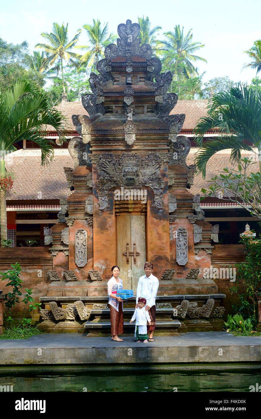 Local family giving a post in one of the small temple in district Ubud ...
