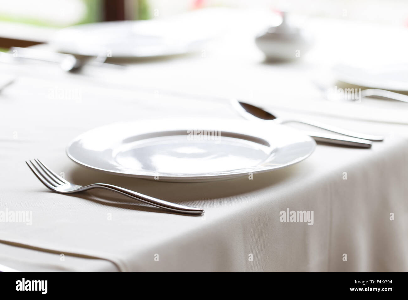 White plate with knife and fork on decorated table Stock Photo - Alamy