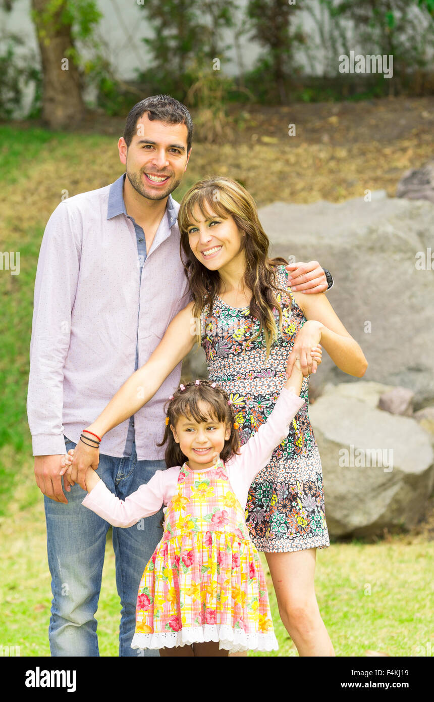 Adorable hispanic family of three posing in garden environment smiling ...