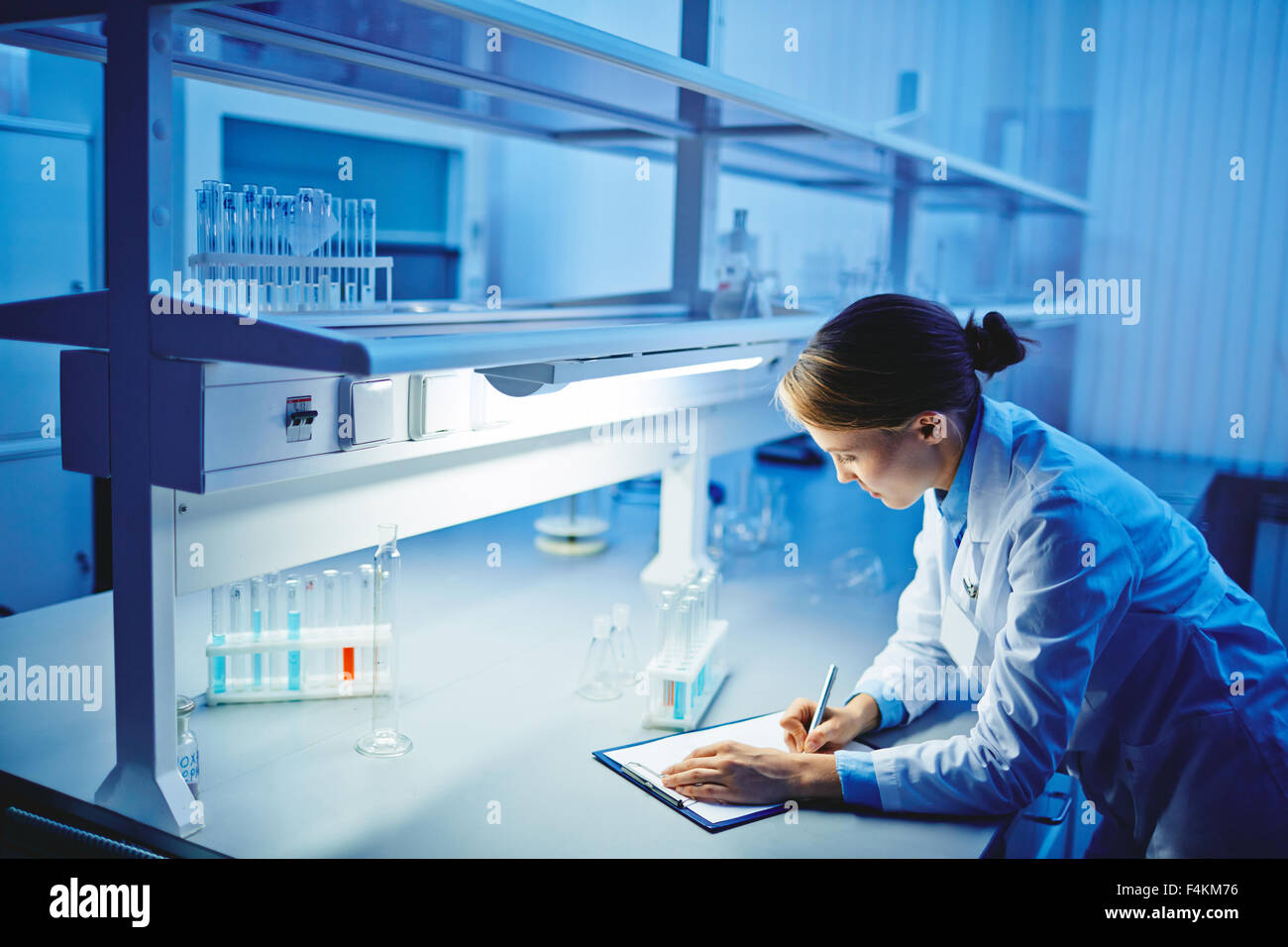 Female microbiologist making notes in laboratory Stock Photo - Alamy