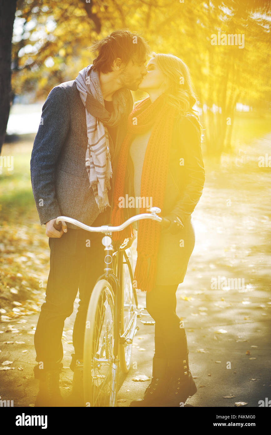 Romantic couple with bicycle kissing in autumn park Stock Photo - Alamy