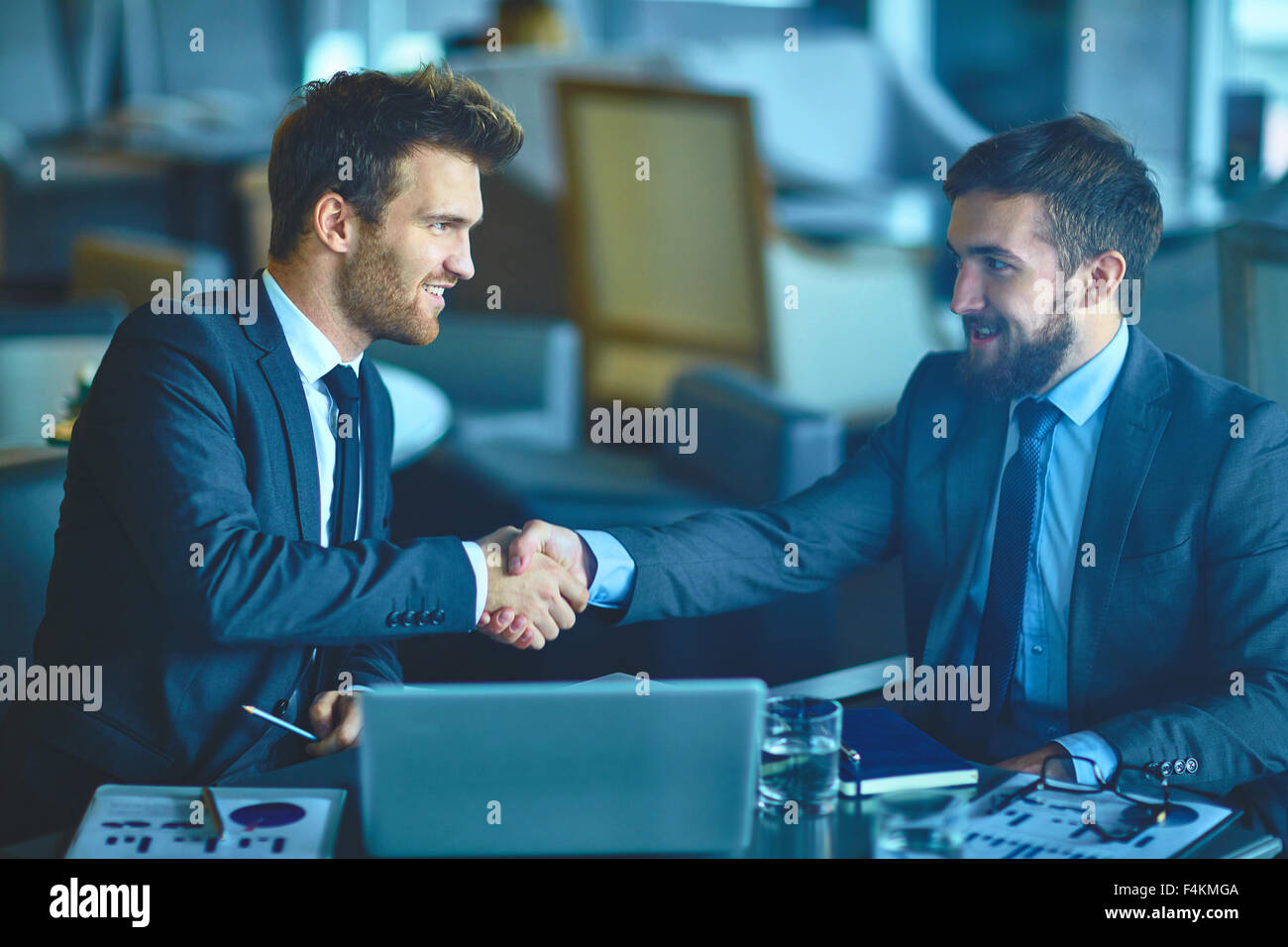 Successful young businessmen handshaking at meeting Stock Photo - Alamy